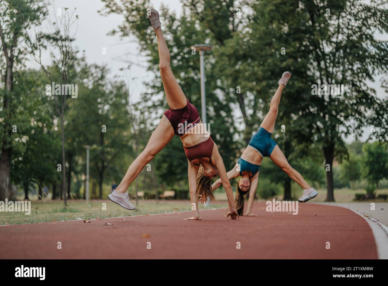 Fit girls confidently performing 360 degree flips, showcasing their strength and flexibility ...