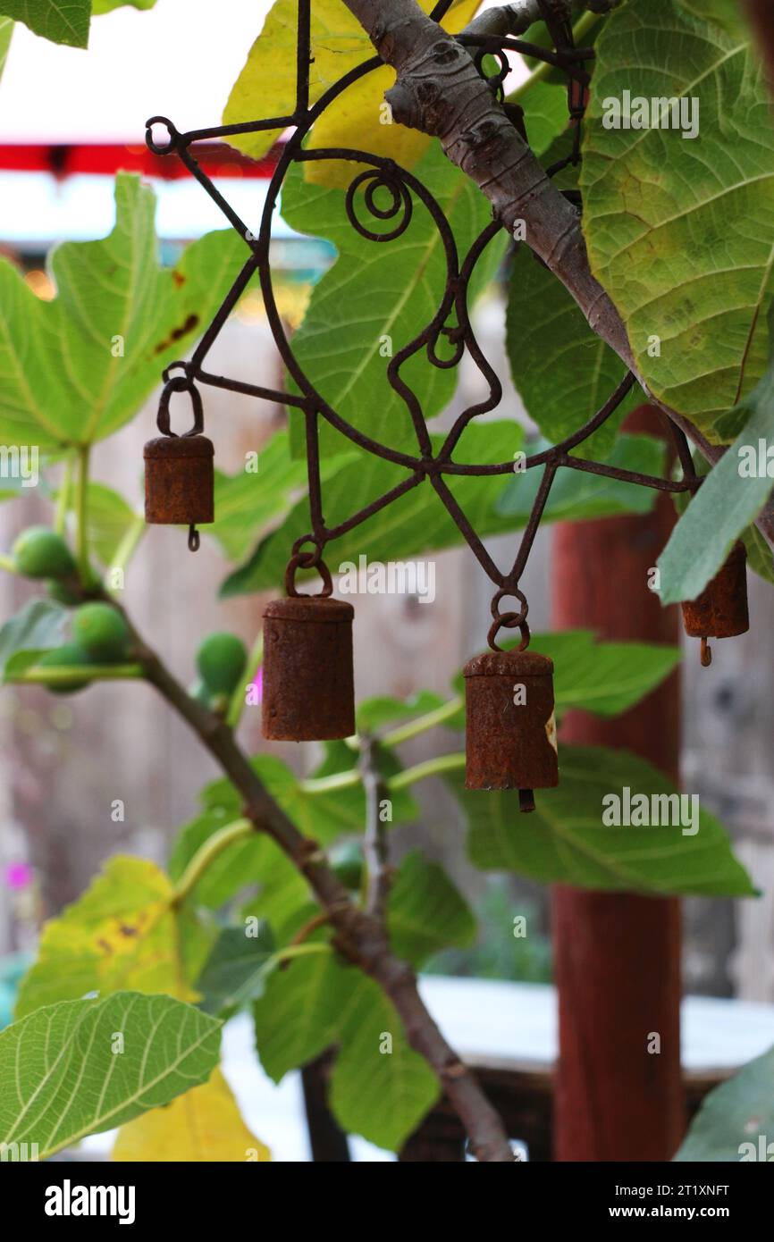 Silhouette of small weathered metal bells in a restaurant garden patio ...