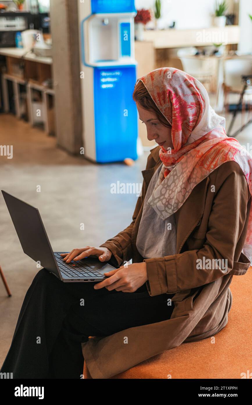 Businesswoman in hijab working on lap top. Side view photo Stock Photo ...