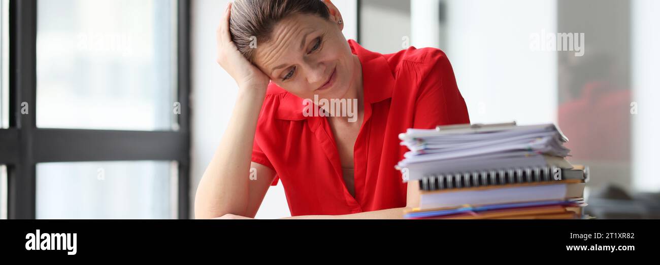 Secretary sits at table near stack of folders with materials Stock ...