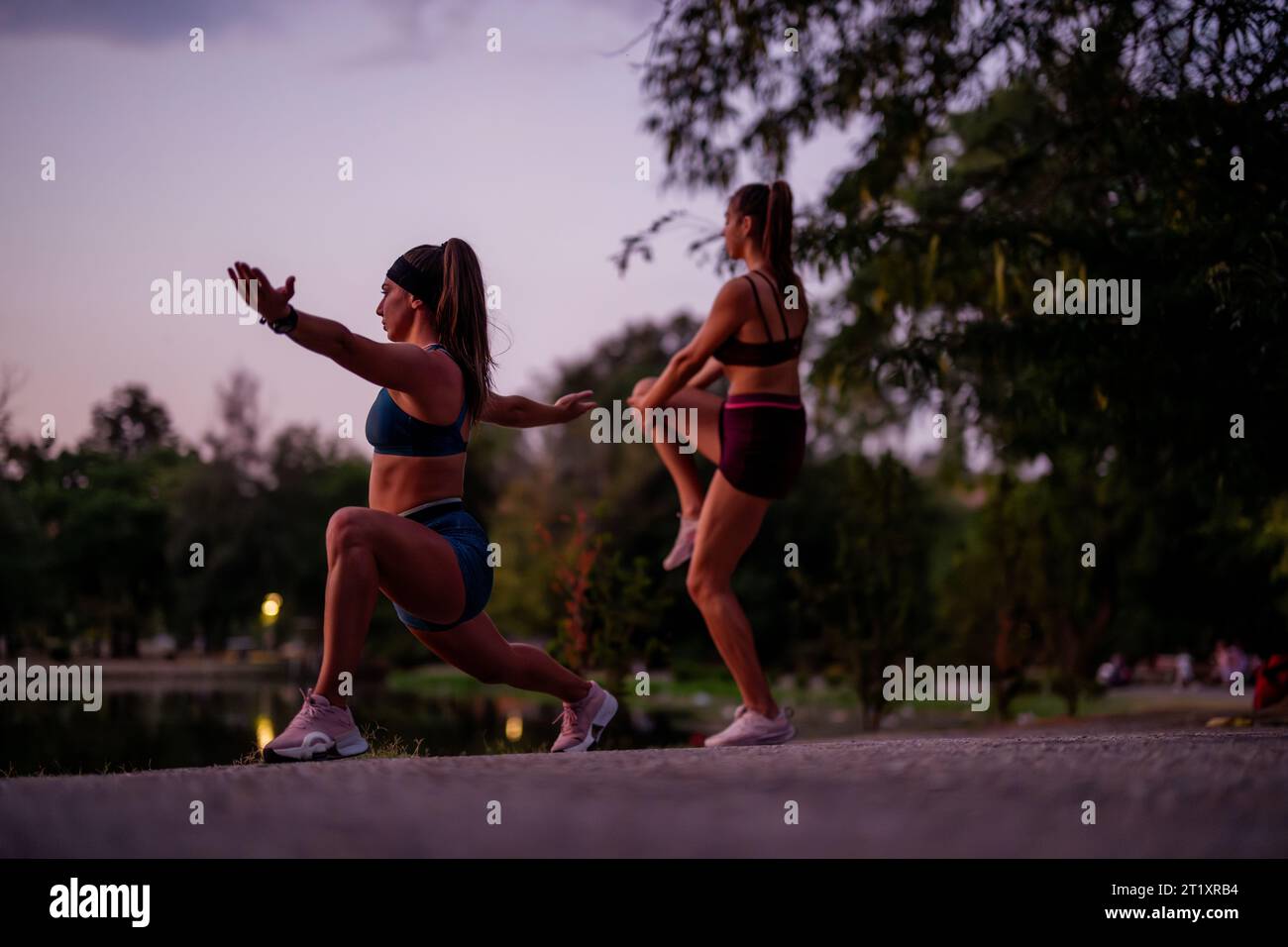 Fit girls in green park, exercising at night. Active and athletic ...