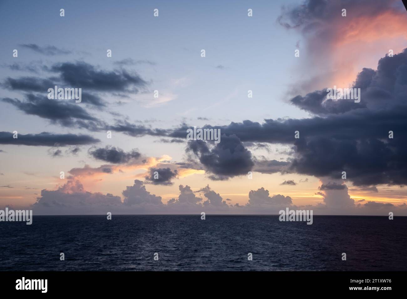 Dramatic clouds at sunrise/sunset sky over the horizon of the Caribbean ...