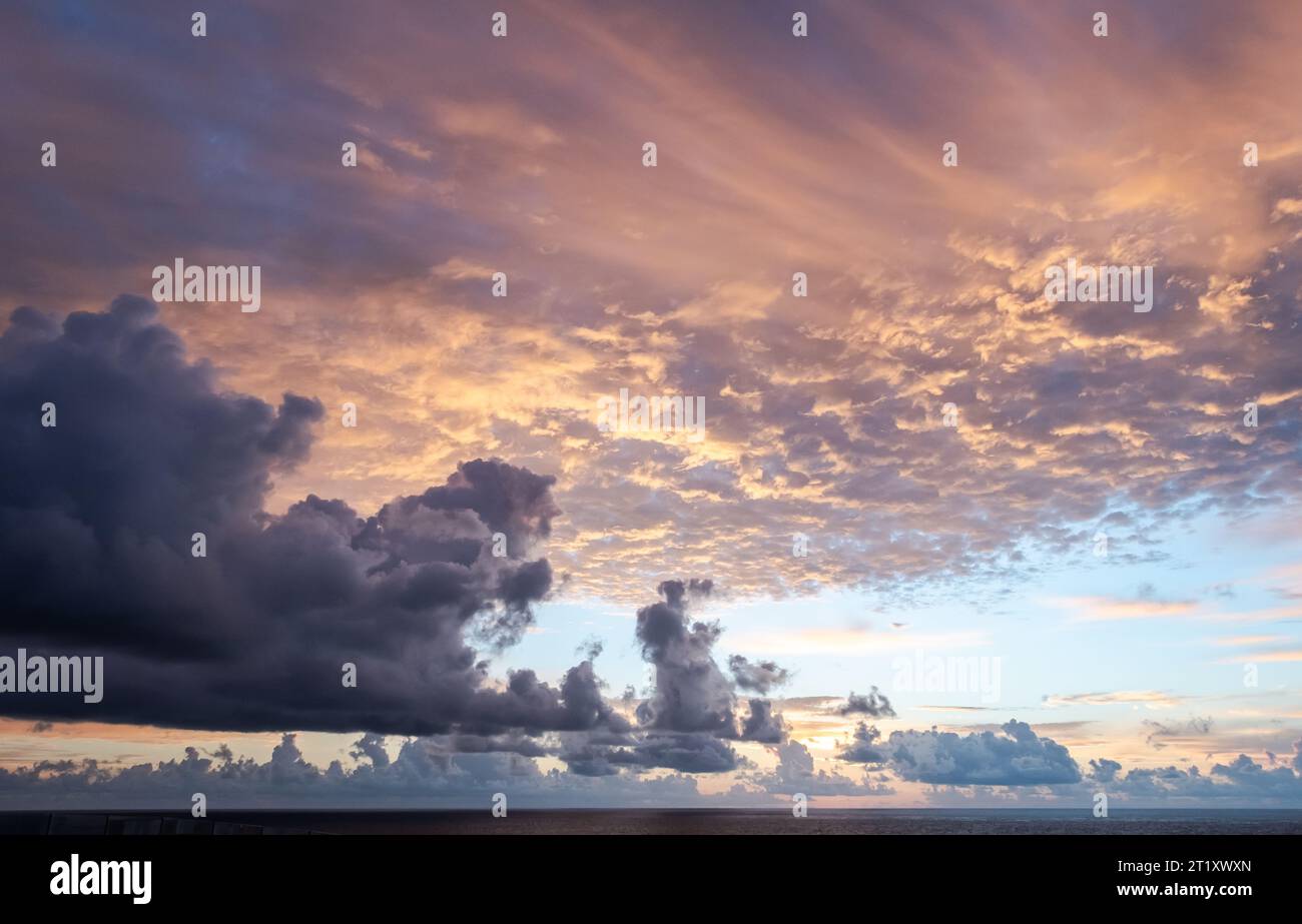 Dramatic clouds at sunrise/sunset sky over the horizon of the Caribbean ...