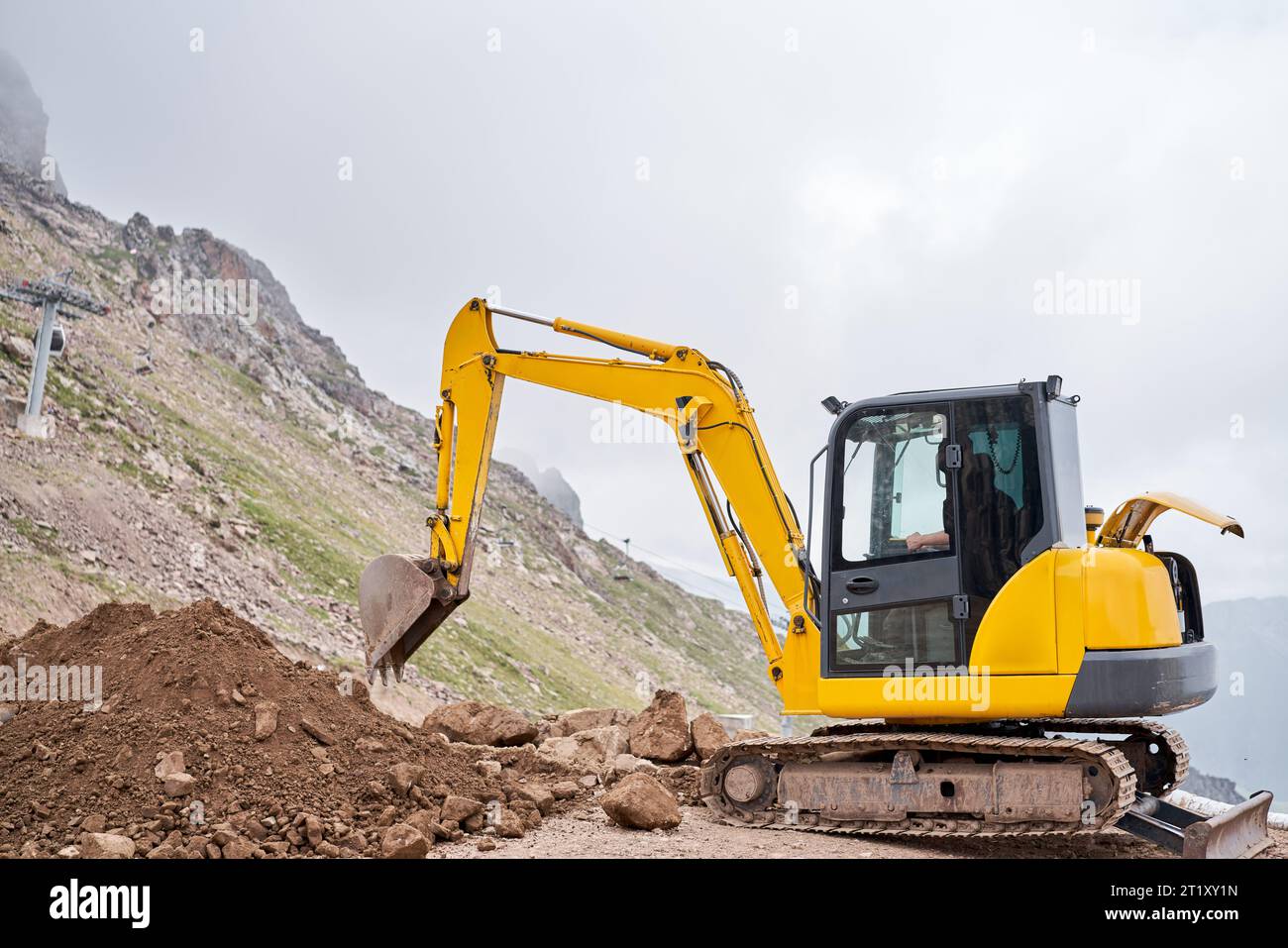 Excavator works in the highlands. Makes a trench for communications ...