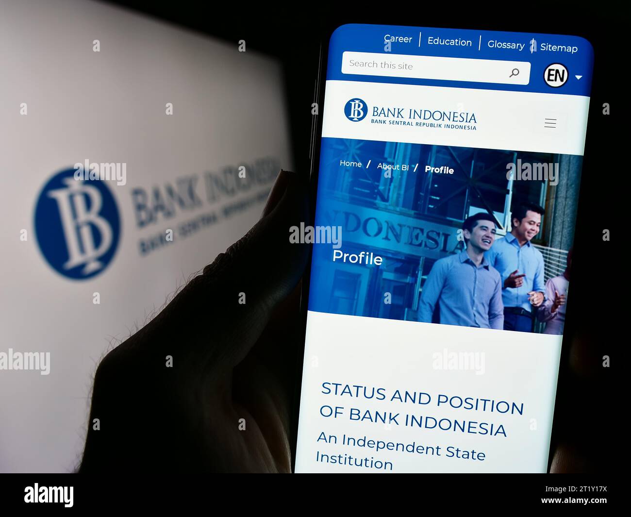 Person holding smartphone with website of Indonesian financial ...