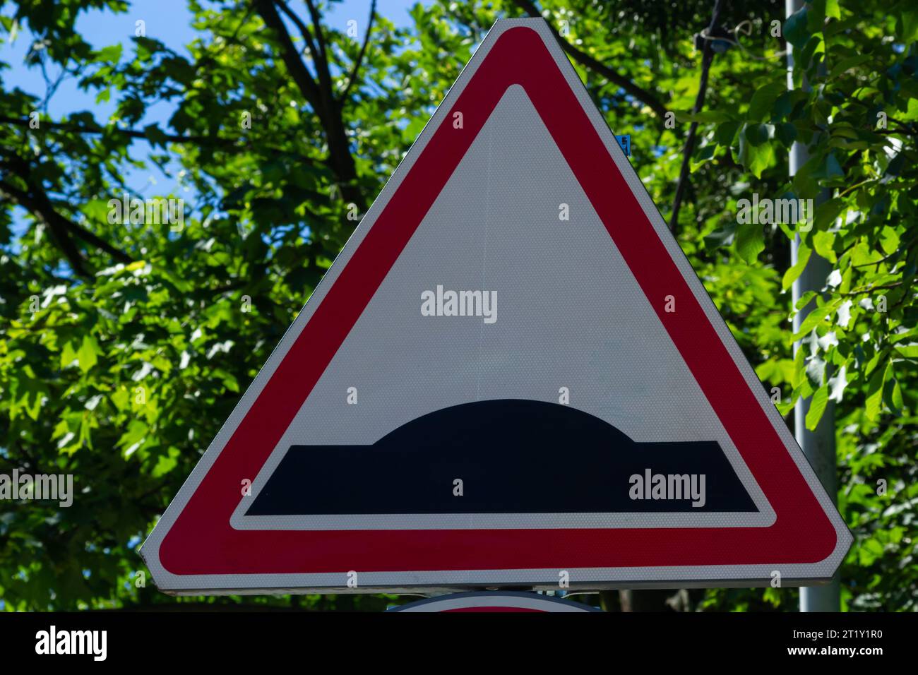 Triangular warning road sign Hump in the road beautiful blue cloudy sky ...