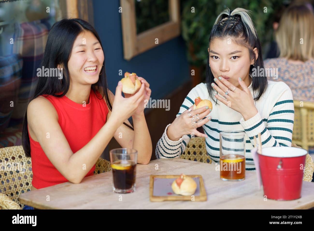 Joyful Asian women eating delicious food during lunch together Stock ...