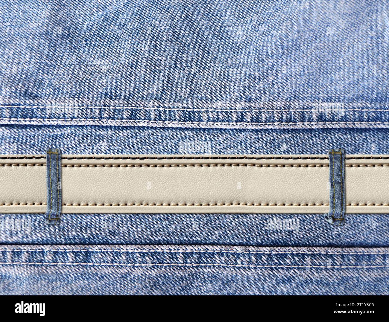 Blue denim background with leather belt of ivory color. Horizontal or ...