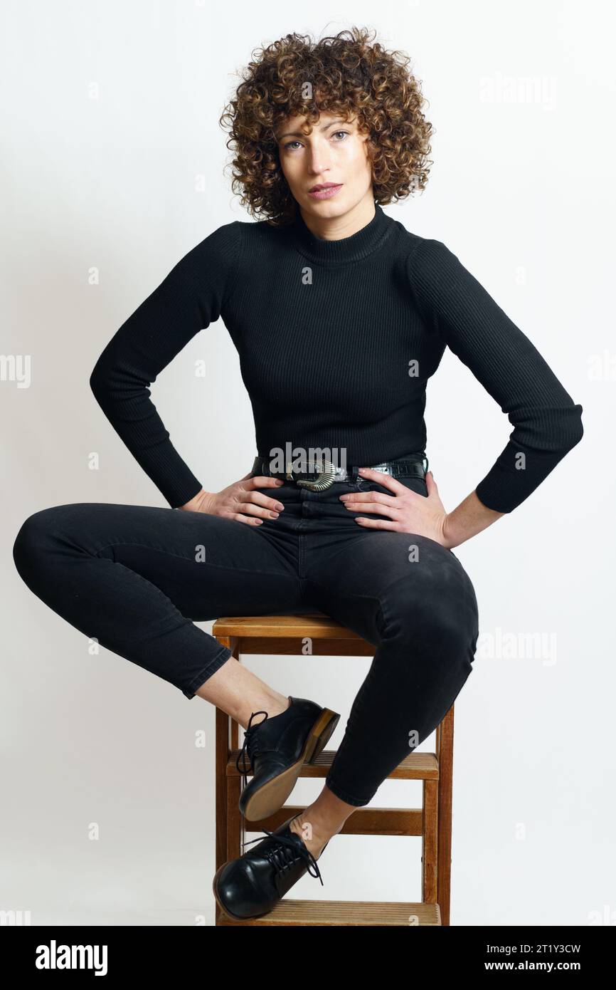 Stylish confident adult female sitting on chair with steps Stock Photo ...