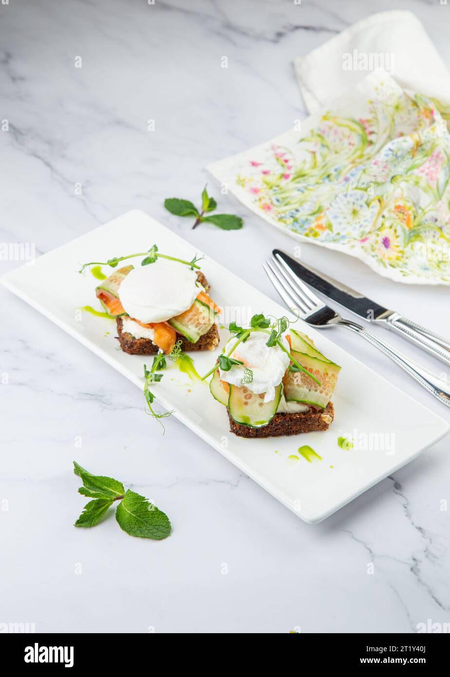canapes on black bread with cheese, red fish, herbs and cucumber side ...