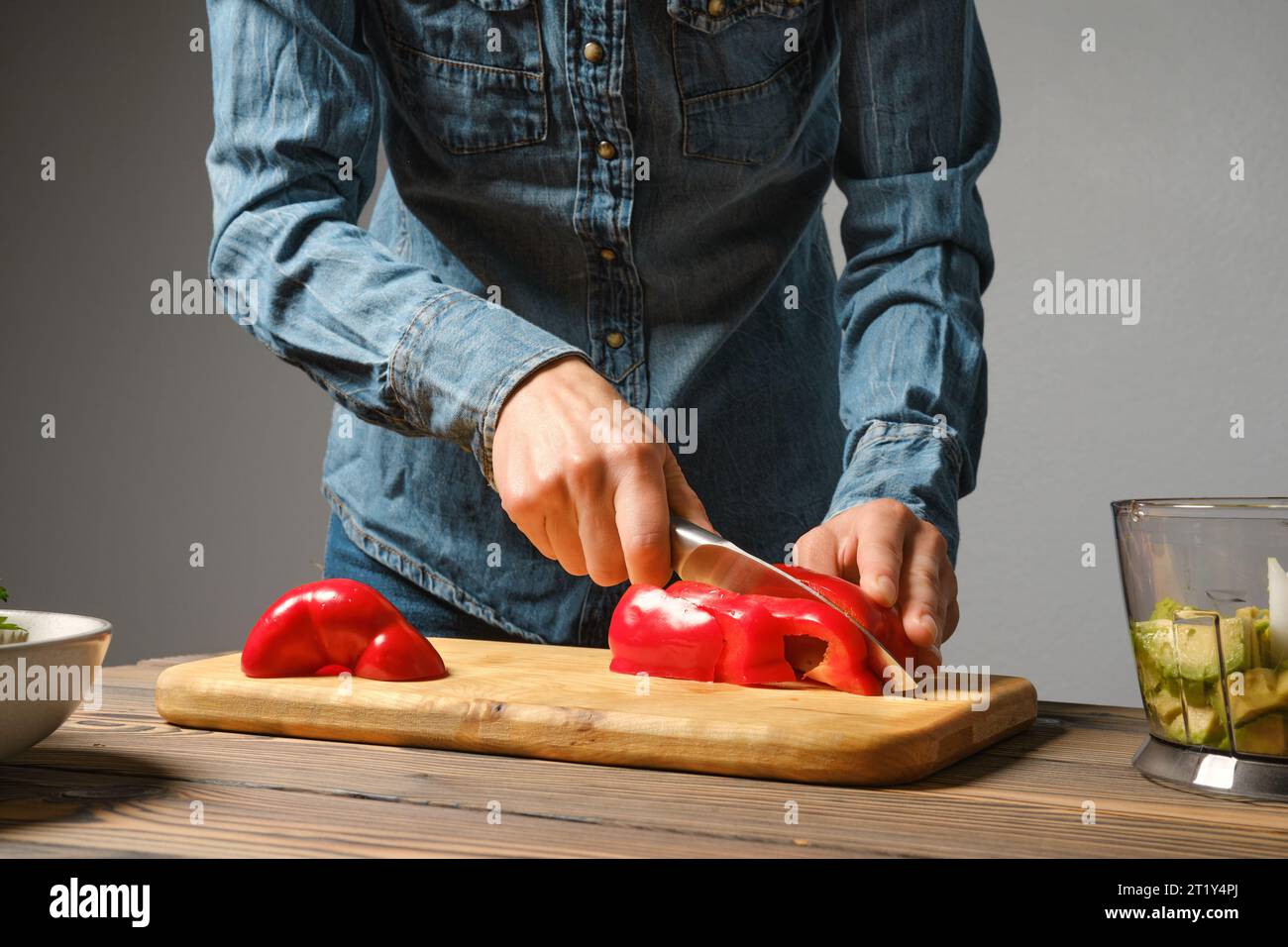 Female hands slicing red bell pepper with kitchen knife Stock Photo - Alamy