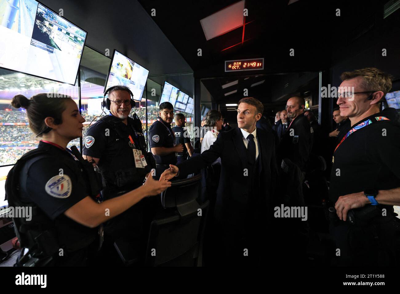 French President Emmanuel Macron (C) shakes hands with a police officer ...