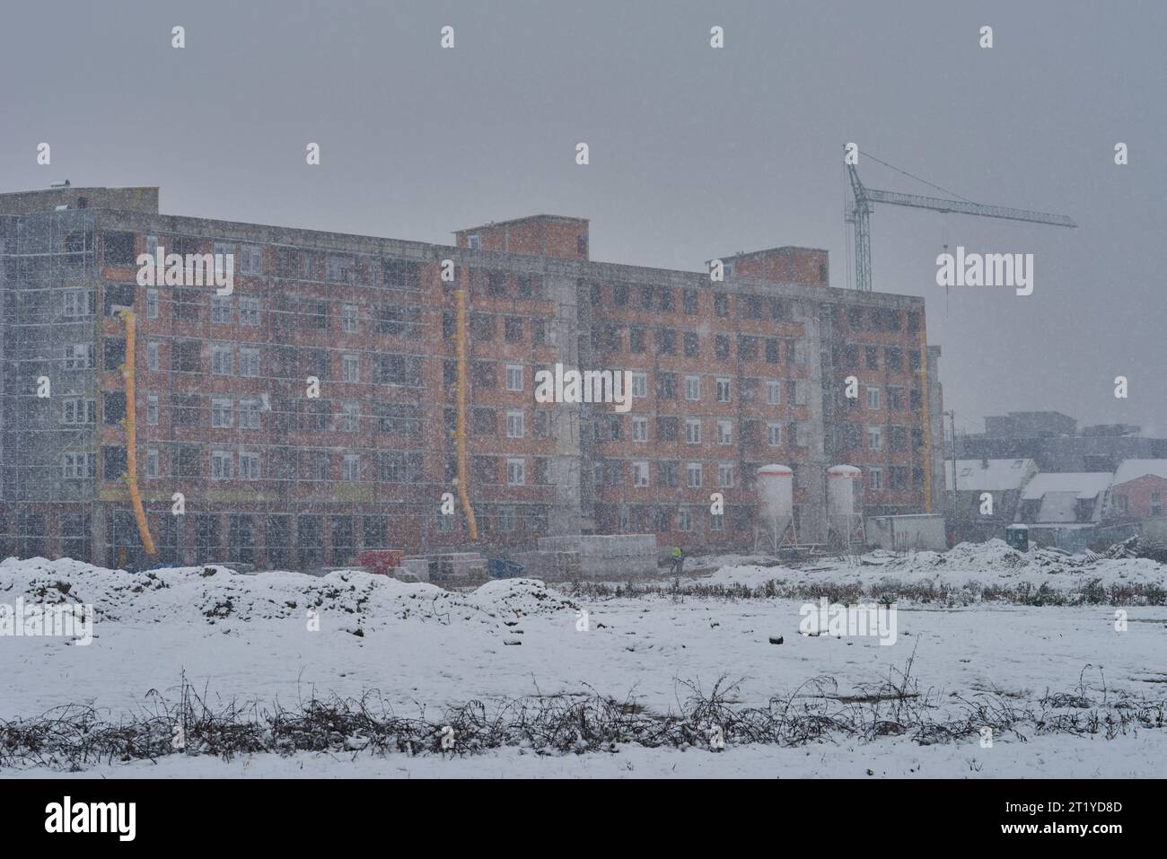 Winter snow storm at building construction site with scaffolding and ...