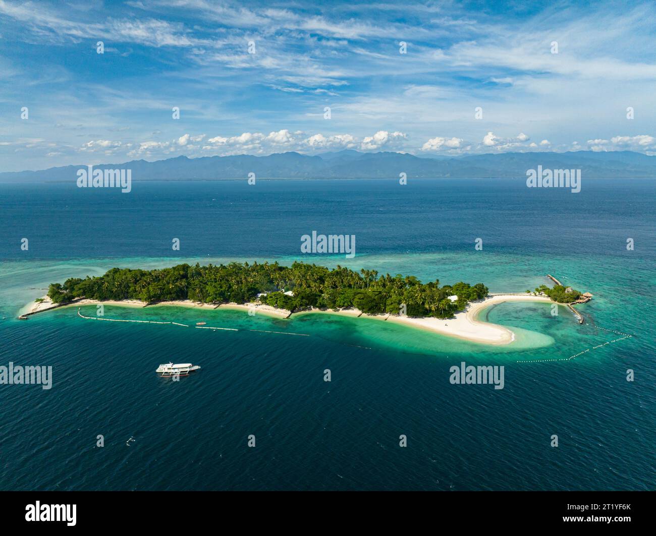 White sand around the island. Boat over the blue sea, blue sky and ...