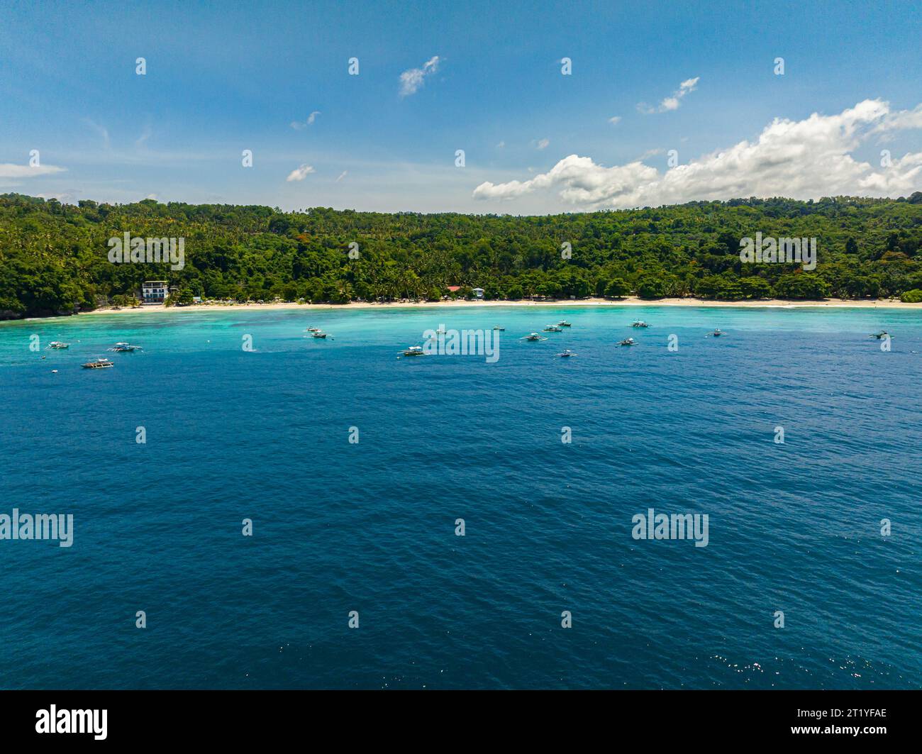 Beach with white sand and ocean waves. Boats floating over the azure ...