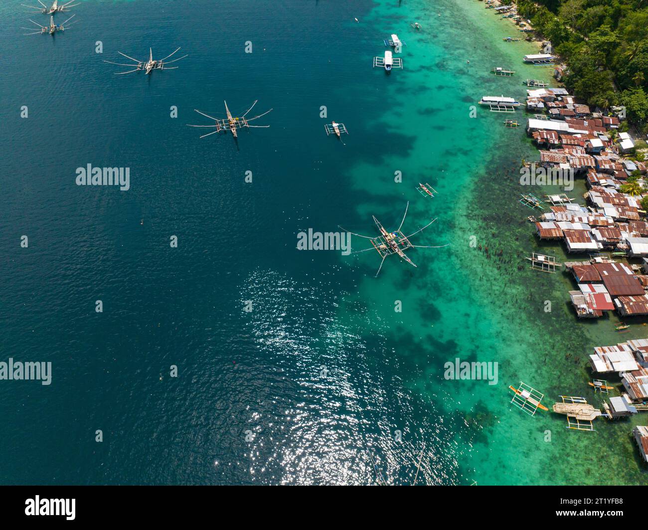 Traditional fishing boats floating over the blue sea, stilt house in ...