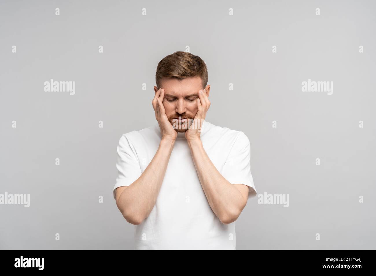 Man holds on to sore head temples. Pain, migraine, headache, aching ...
