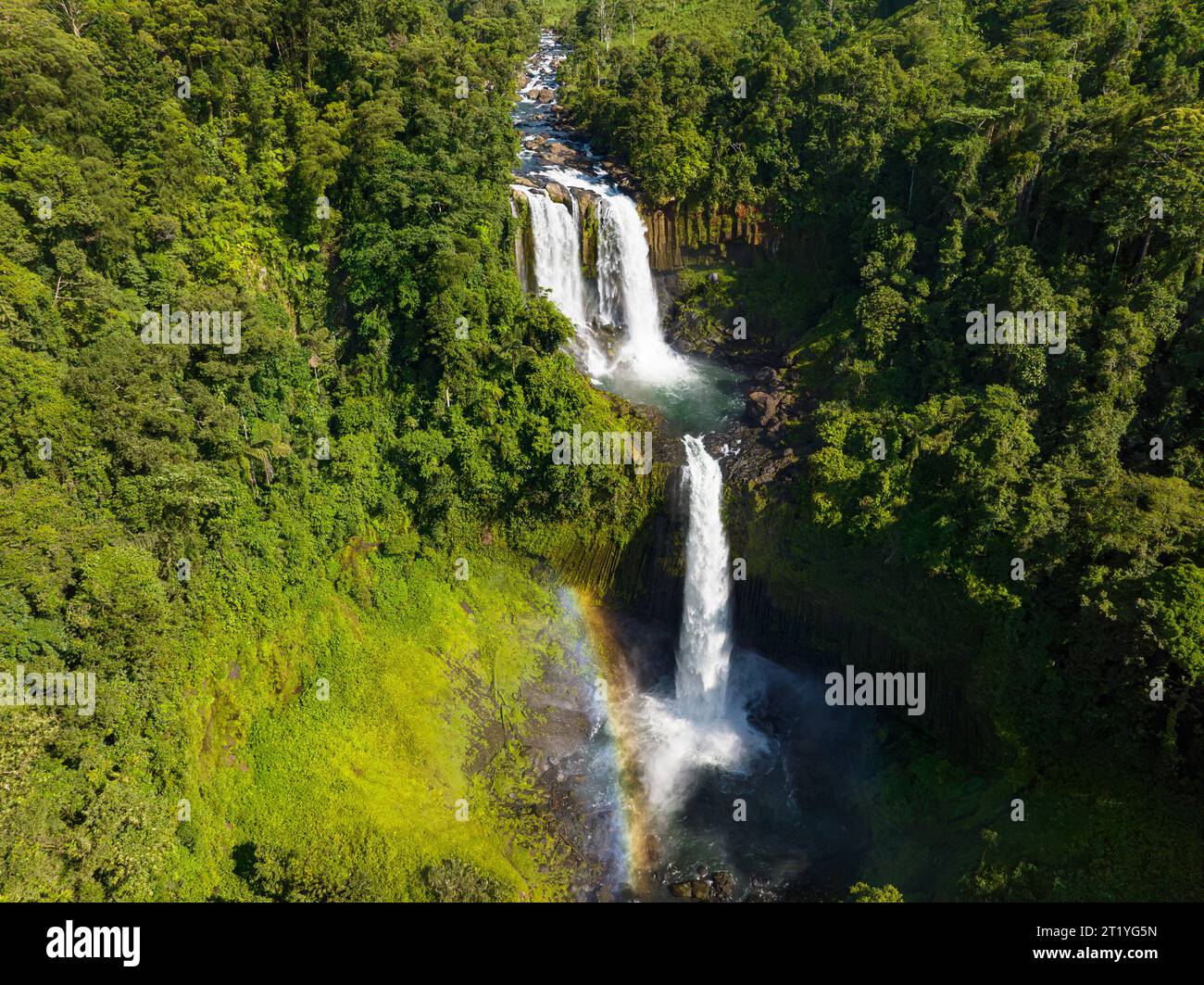 Tropical waterfalls in mountain covered by rainbow. Limunsudan Falls ...