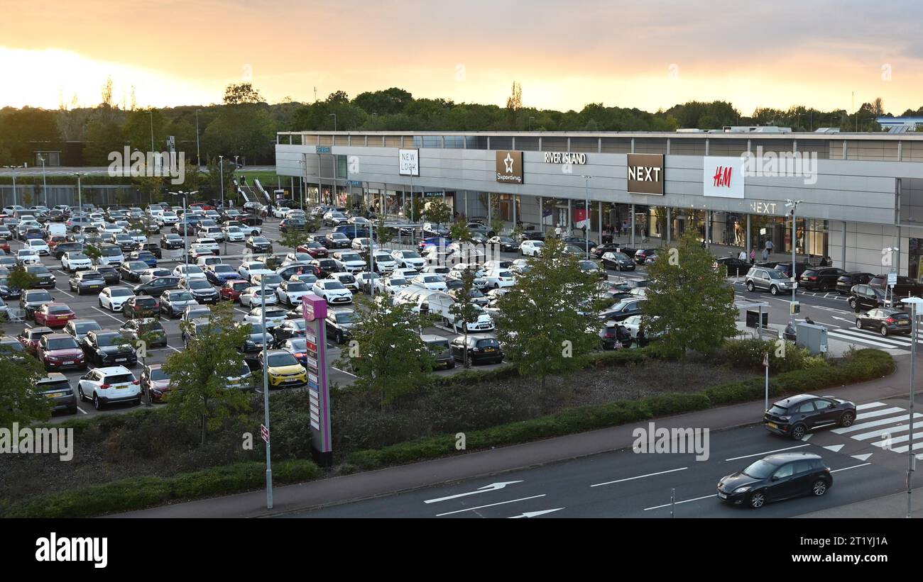 Cars parked in a car park by a shopping mall at sunset Stock Photo - Alamy