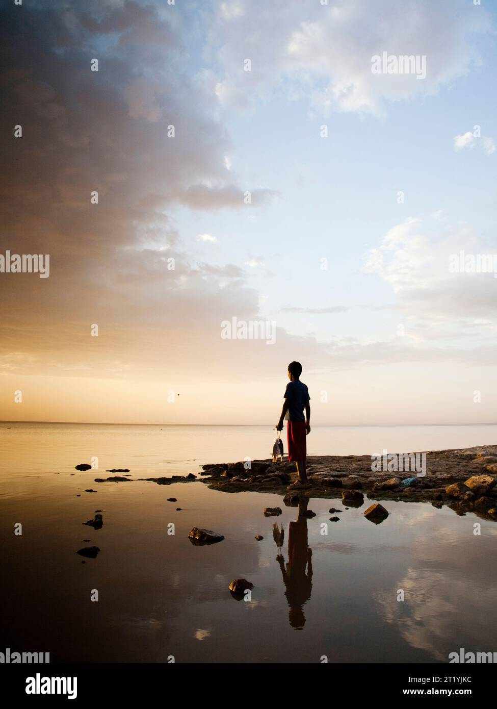 A young Ethiopian boy holds his fresh catch on the shores of Lake ...