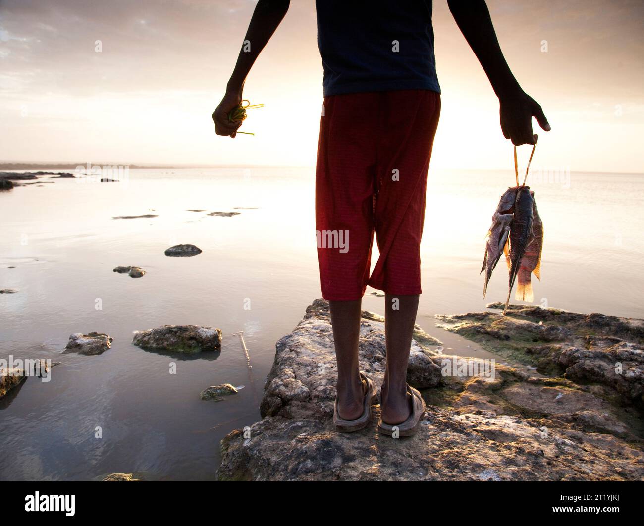 A young Ethiopian boy holds his fresh catch on the shores of Lake ...