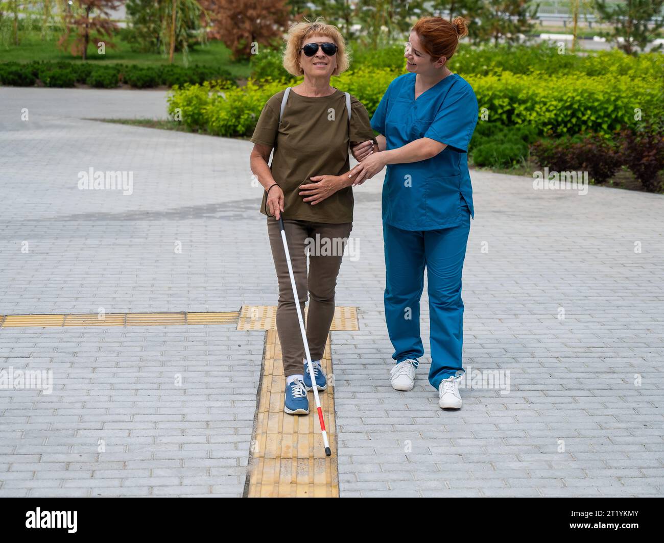 A nurse accompanies an elderly blind woman on a walk Stock Photo - Alamy