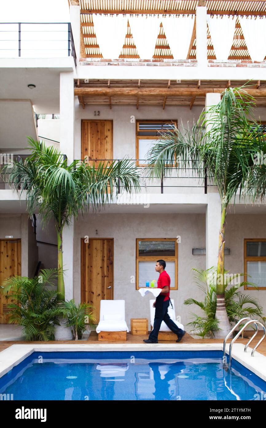 A waiter carries two cocktails next to a pool at a hotel in Todos ...