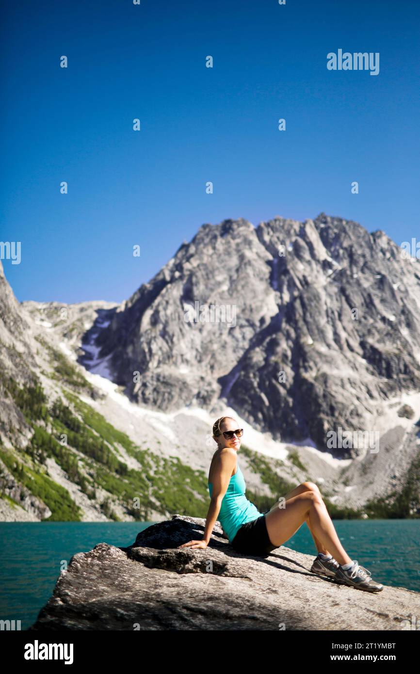 Colchuck Lake, Alpine Lakes Wilderness, Washington, USA. A young woman ...