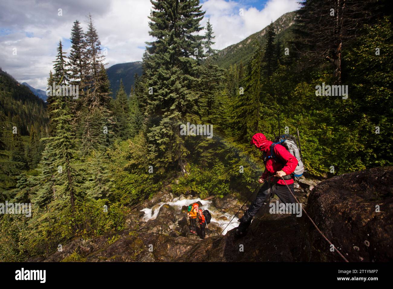 A climber descends a rocky route alongside a waterfall in northern ...