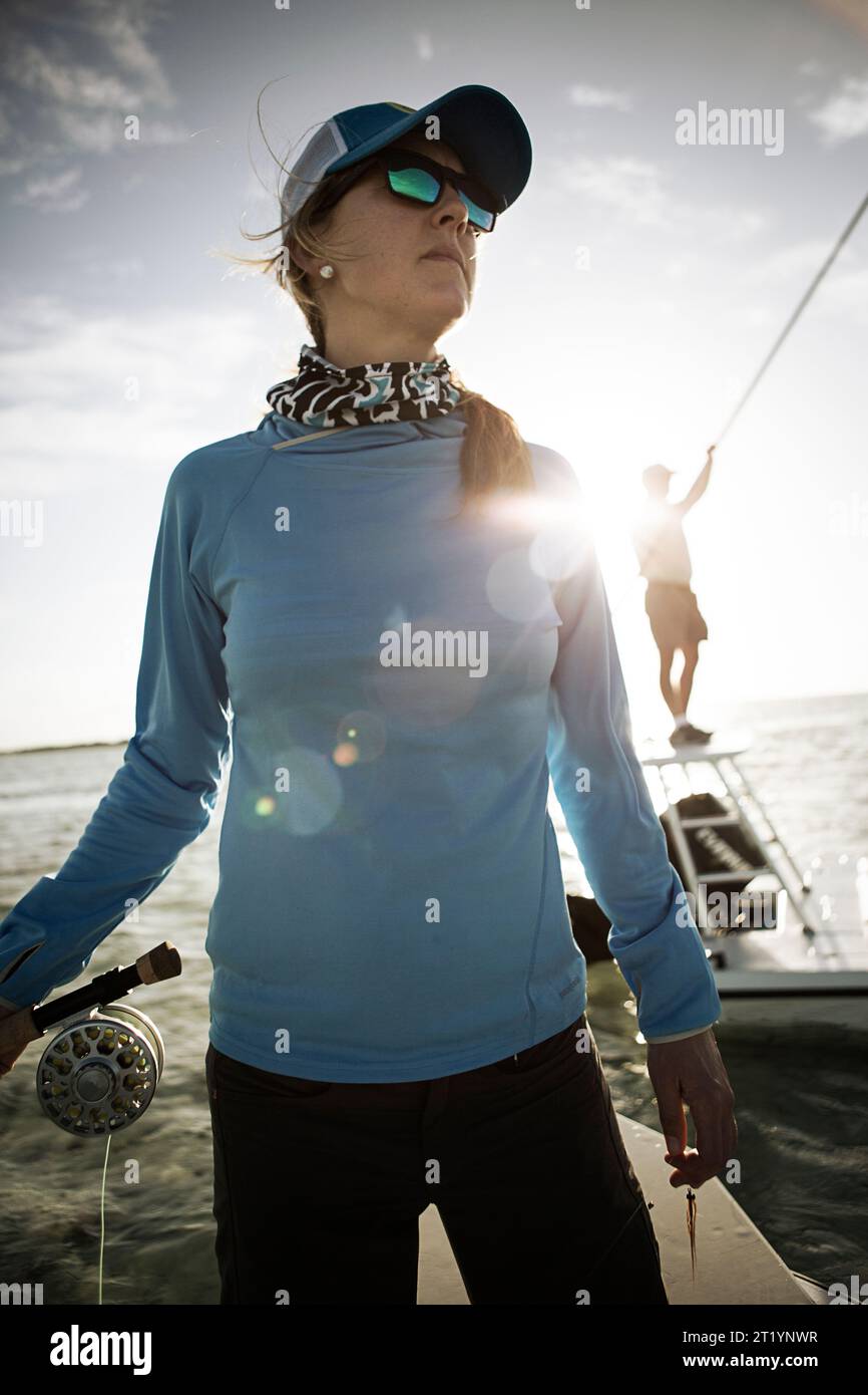 Woman on motorboat holding fishing rod Stock Photo - Alamy