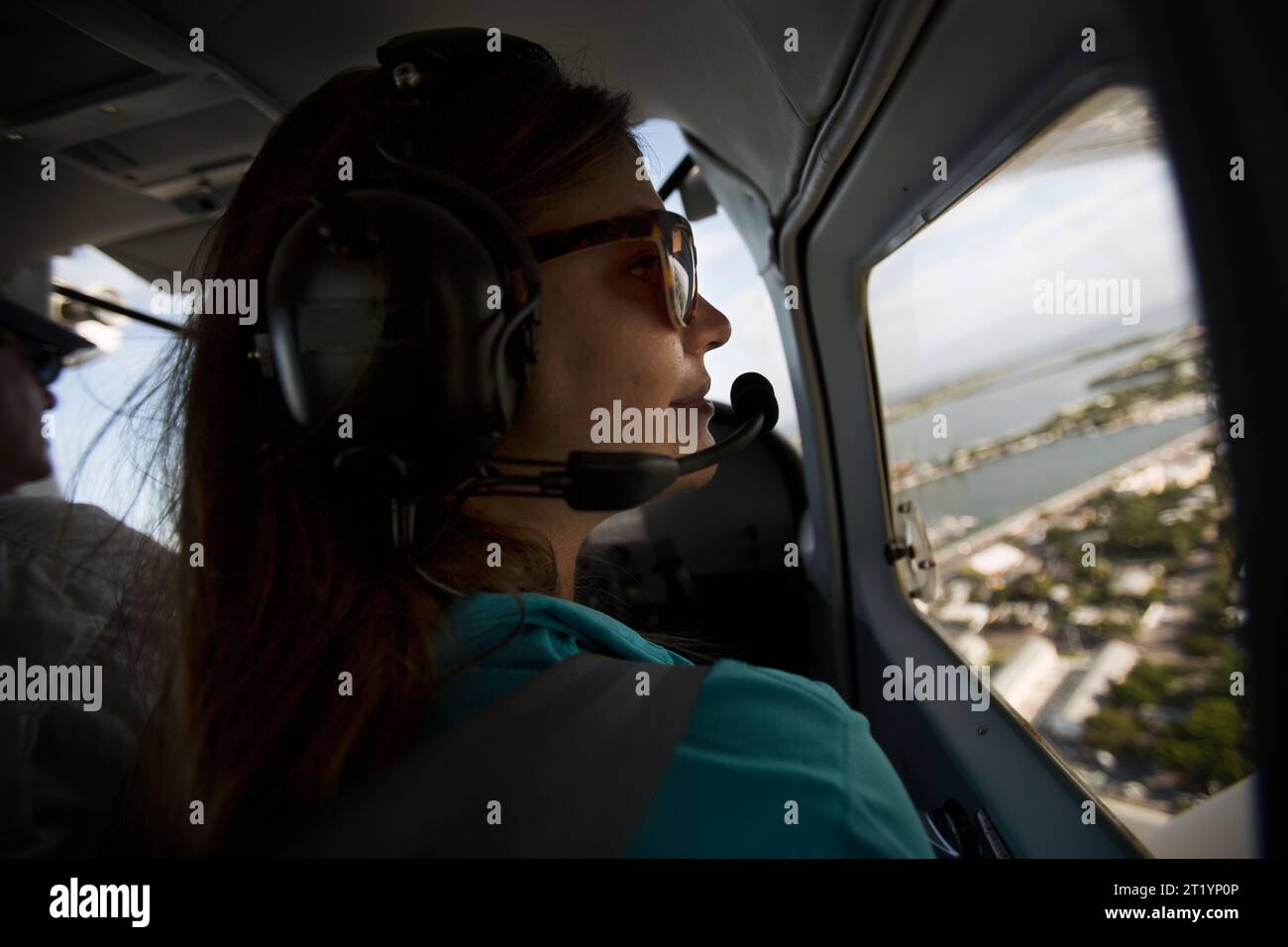 Woman looking through airplane window Stock Photo - Alamy