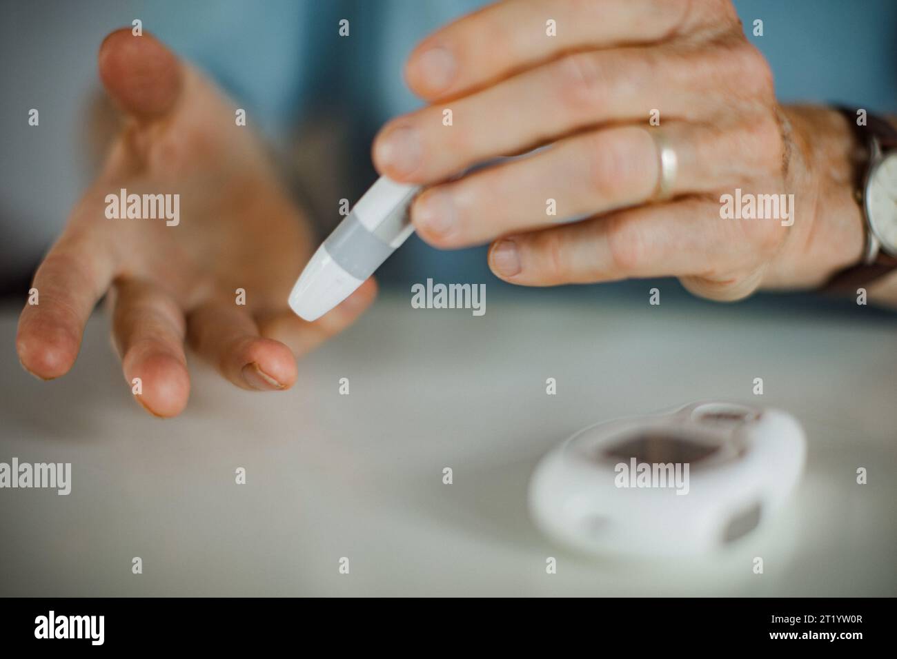 Diabetic senior man on wheelchair checking blood sugar level with ...