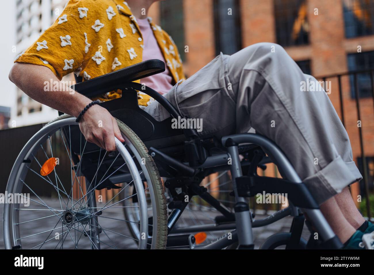 Close up of young Gen Z boy in a wheelchair in the city. Inclusion ...