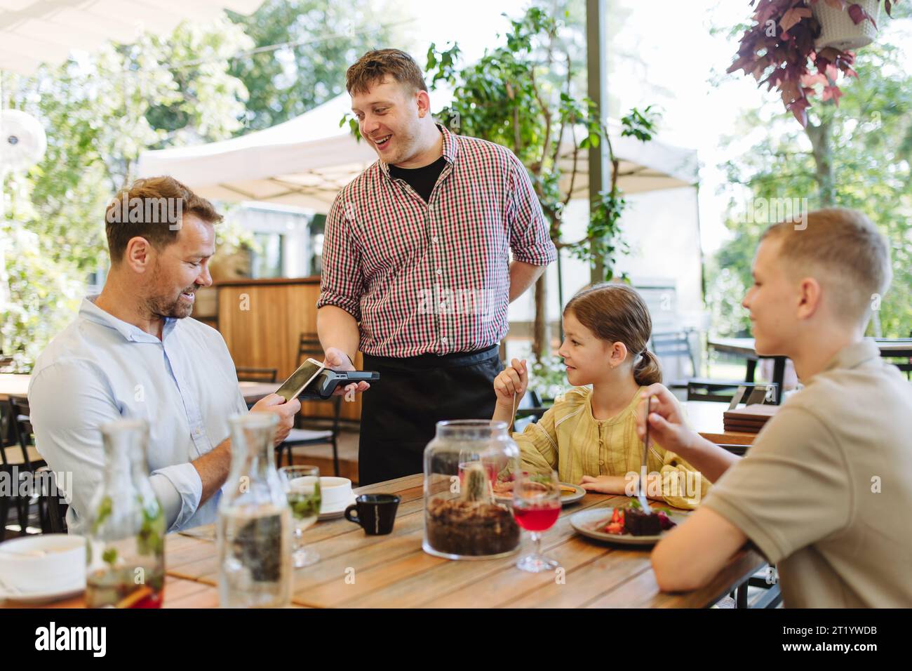 Father and children ordering food from waiter. Single-parent family ...