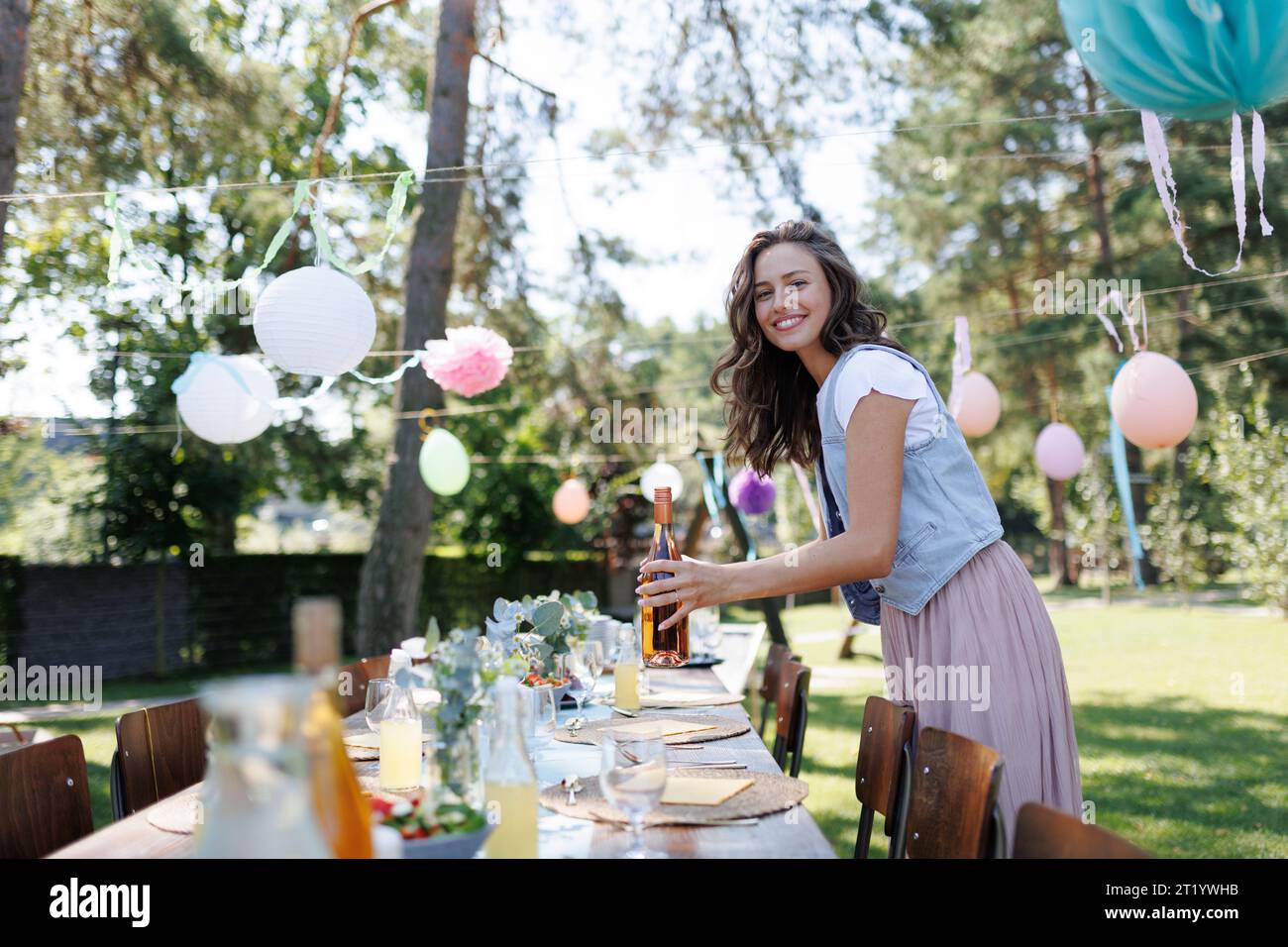 Young beautiful woman preparing refreshments for summer garden party ...