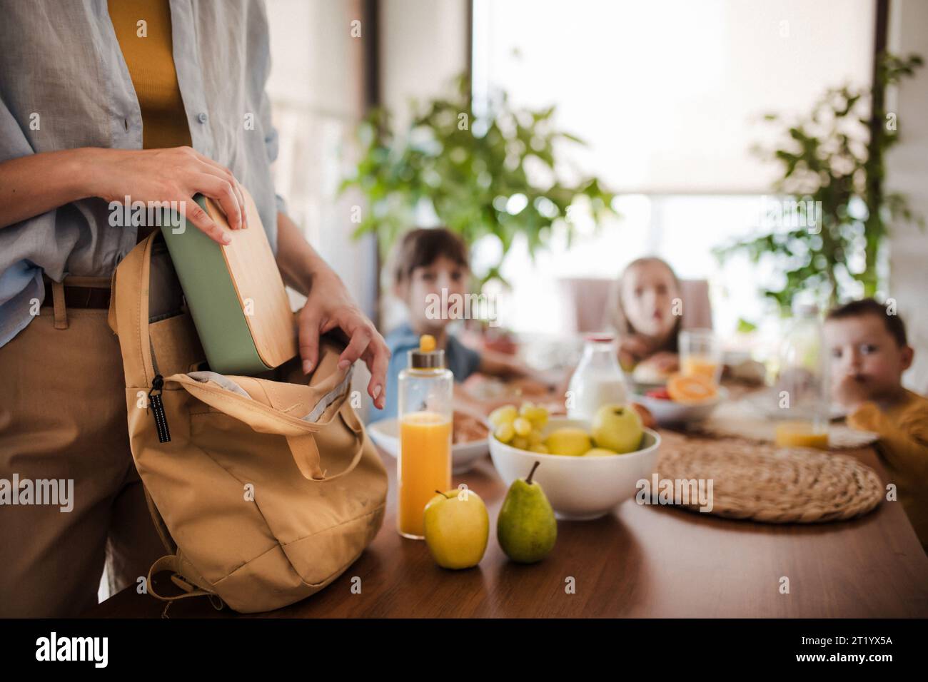 Mother packing school snacks for her children into school bag. Snack ...