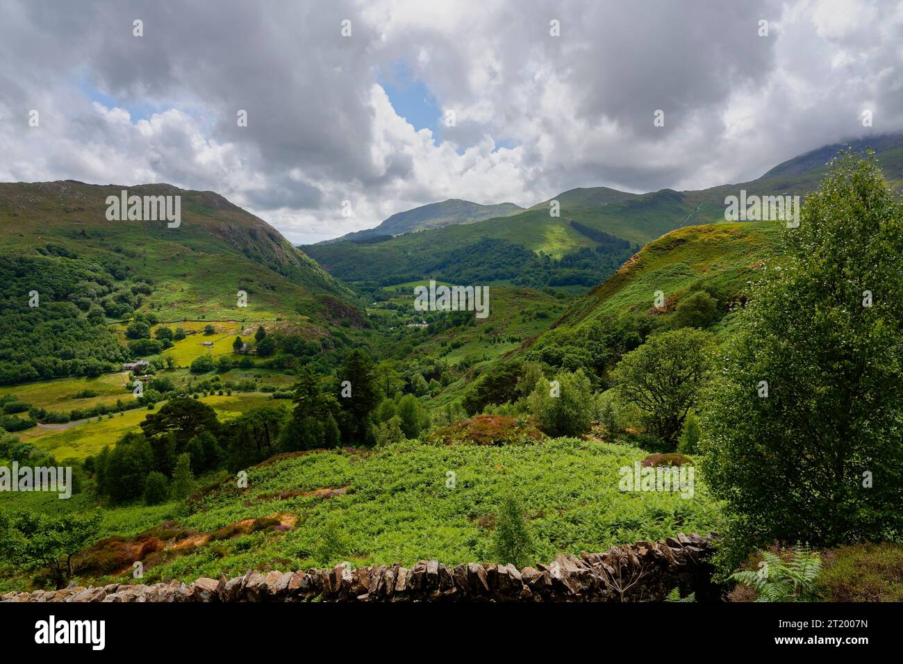 Among the dark clouds in the skies above the Welsh hills small patches ...