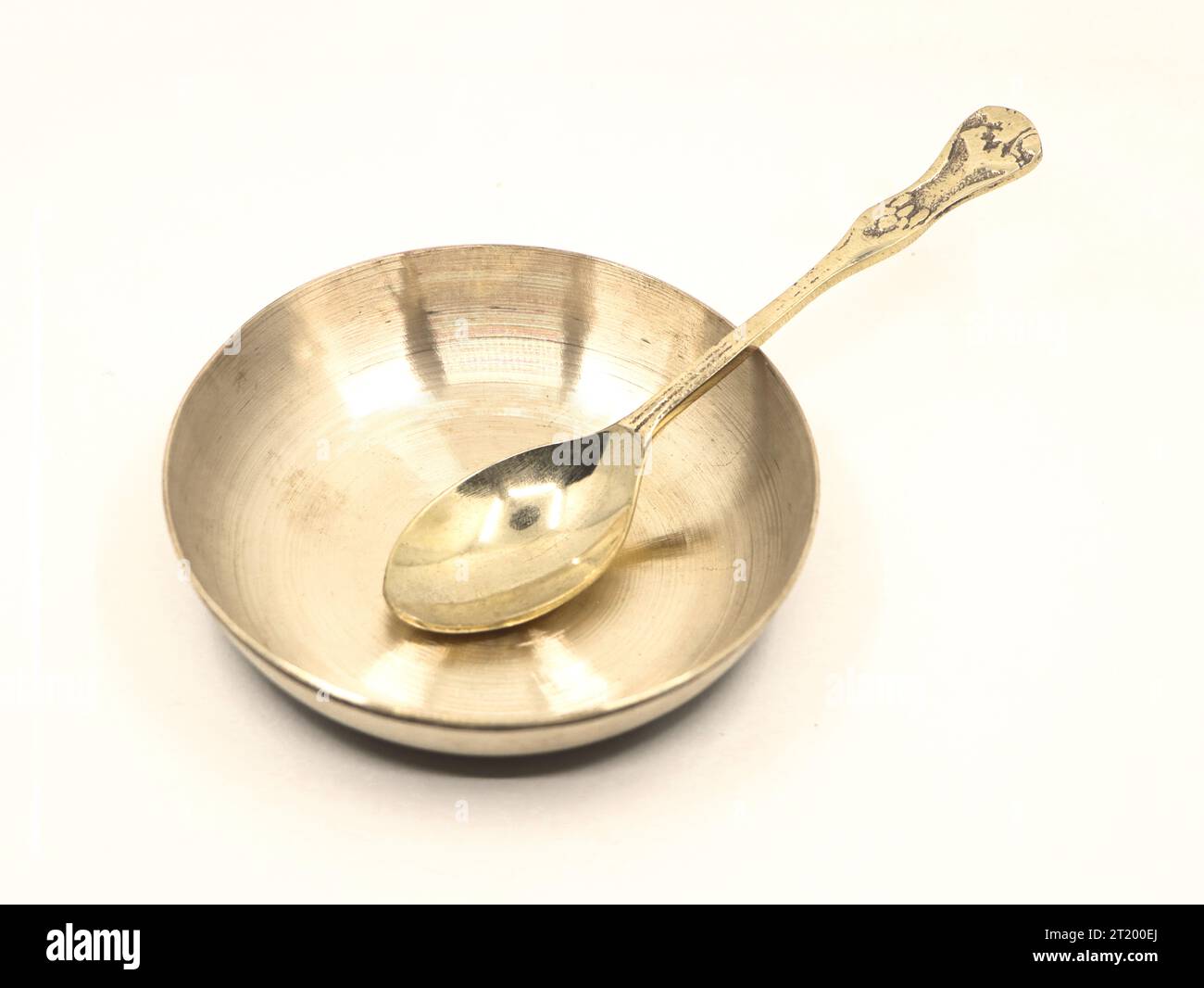 closeup of a shiny vintage bronze metal spoon and bowl used in luxury ...
