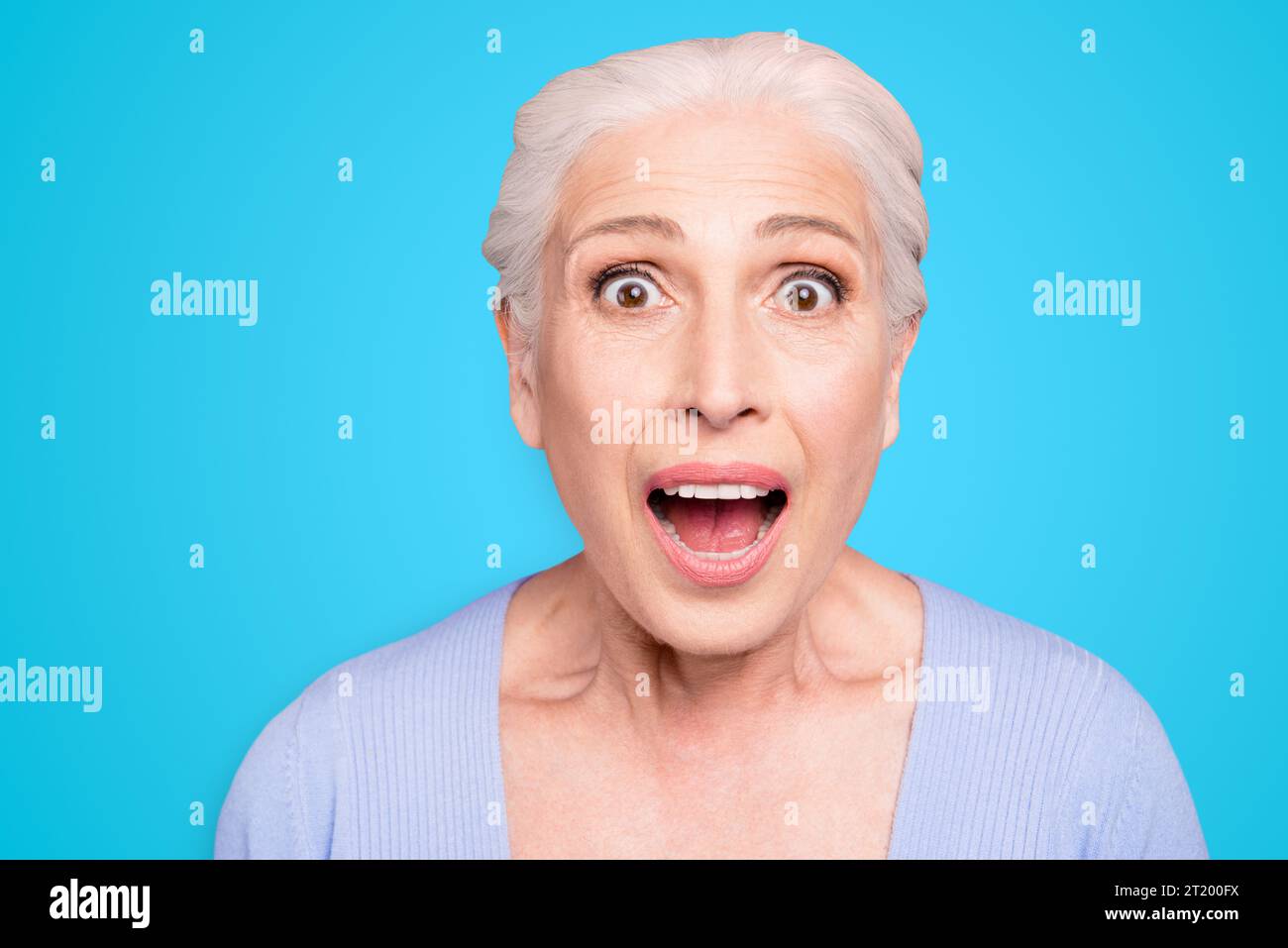 Portrait of gray haired old beautiful angry shocked woman with opened ...