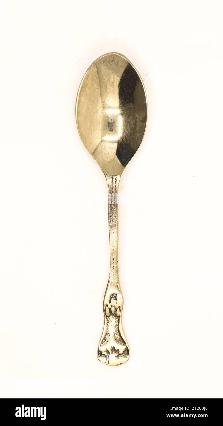 a shiny, clean and old antique bronze metal spoon used by royalty ...