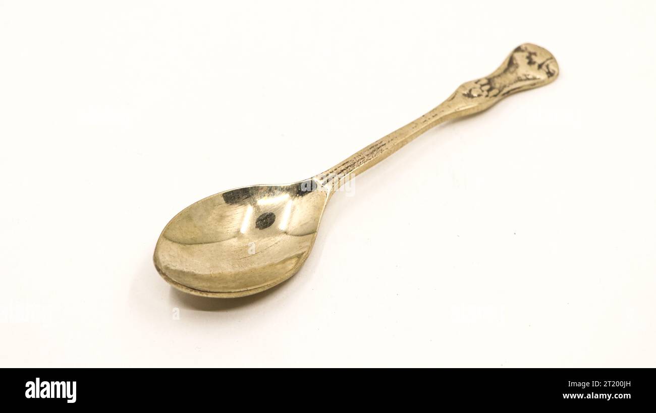 a shiny, clean and old antique bronze metal spoon used by royalty ...
