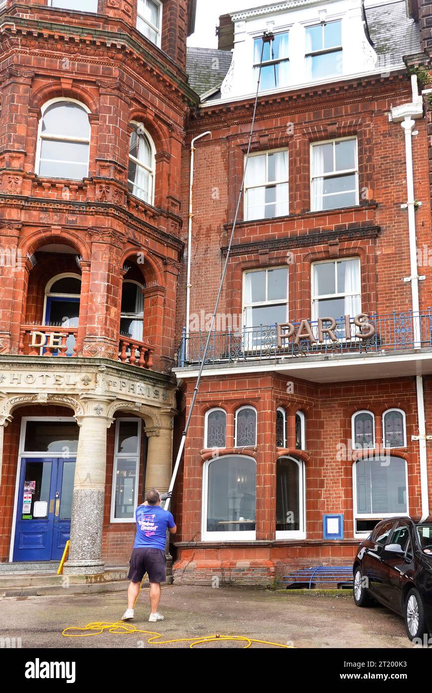 Window cleaner workman operating an extendable water fed light weight ...