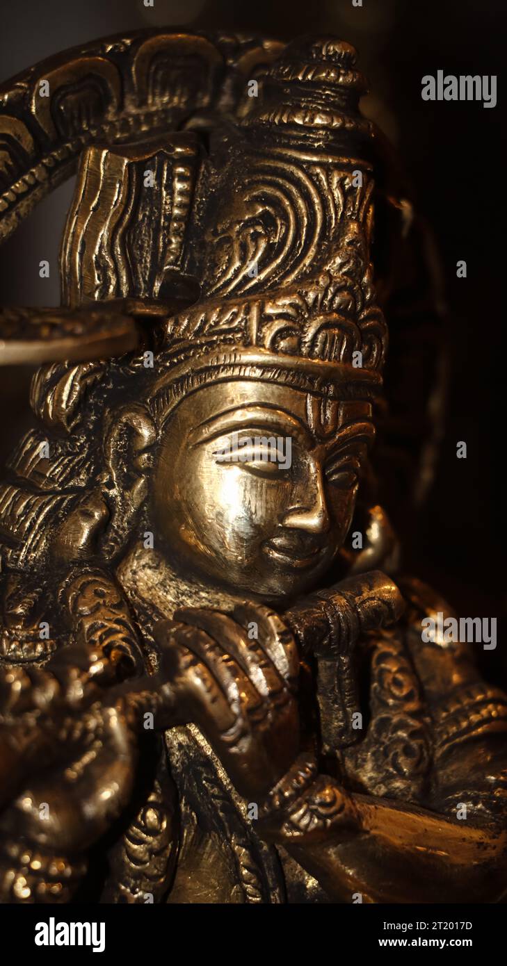 closeup of a shiny stone sculpture of hindu god lord krishna playing ...