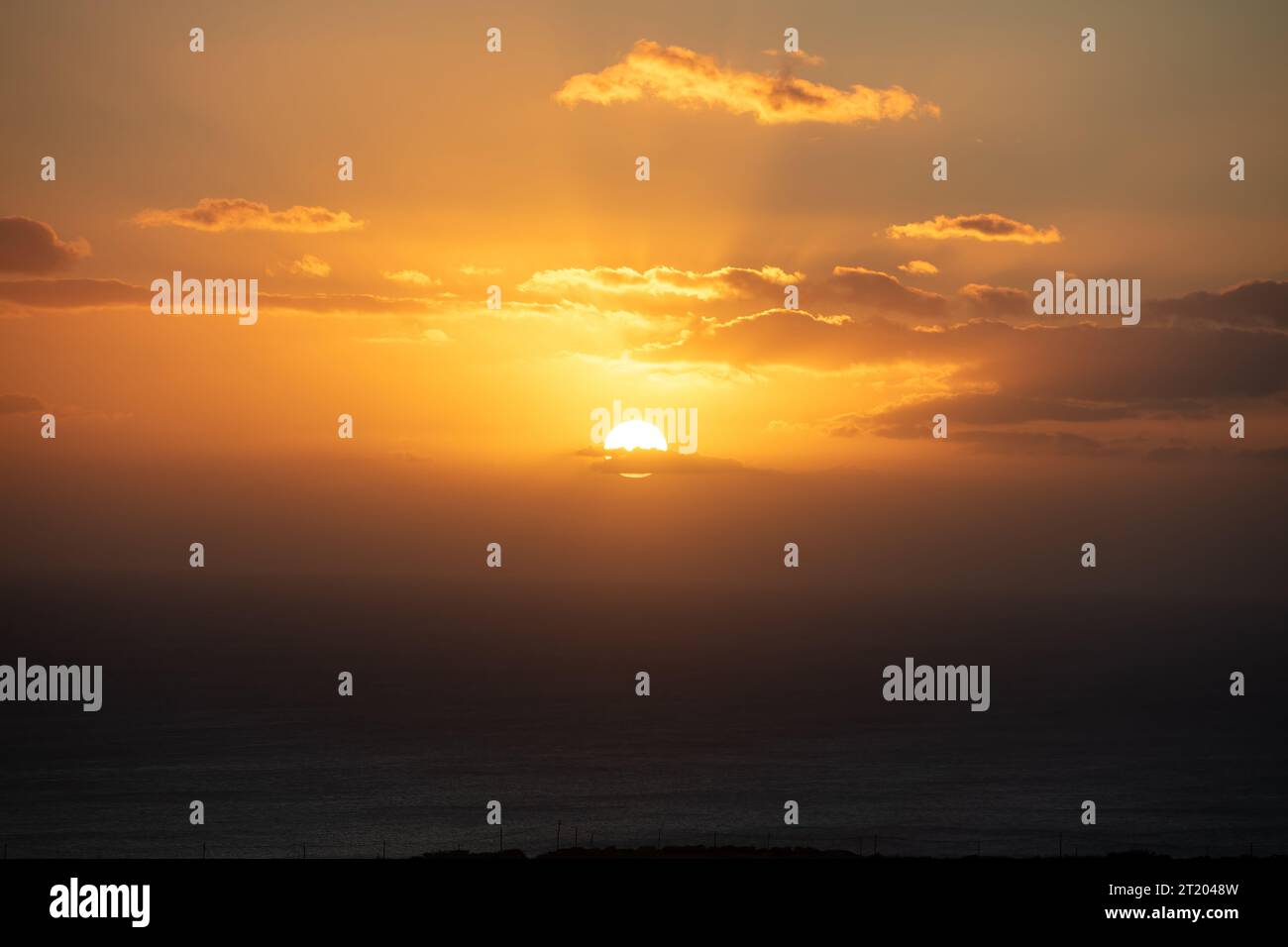 Sunset through and behind the cloudscape over the sea background ...