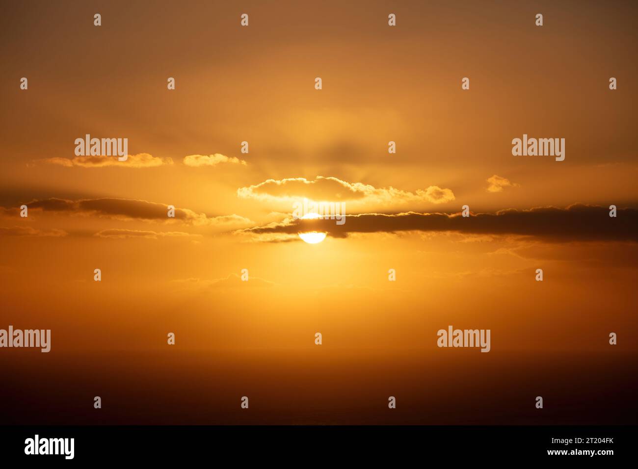 Sunset through and behind the cloudscape over the sea background ...