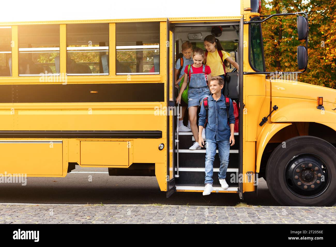 Group of cheerful kids hopping off the yellow school bus Stock Photo - Alamy