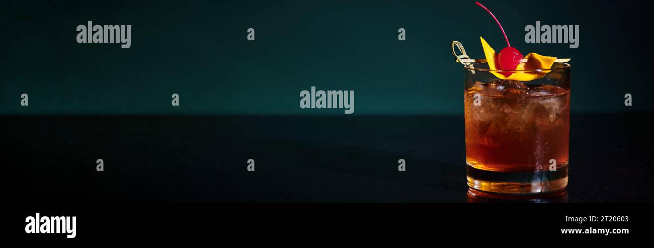 ice cold glass of negroni garnished with cocktail cherry on black ...