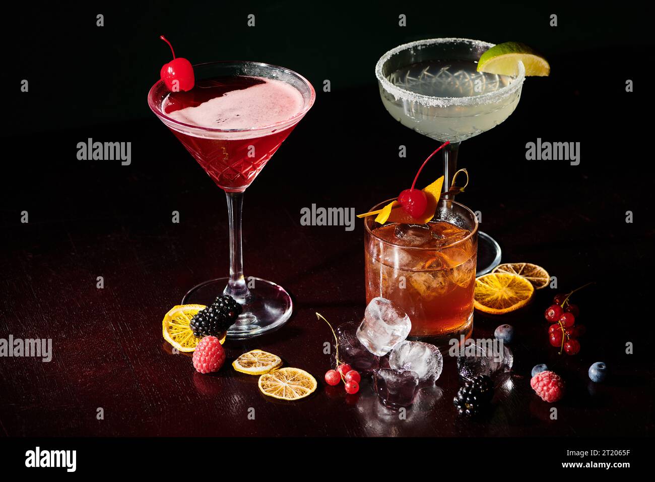 zesty and delicious cocktails with cherries, ice and lime on black ...