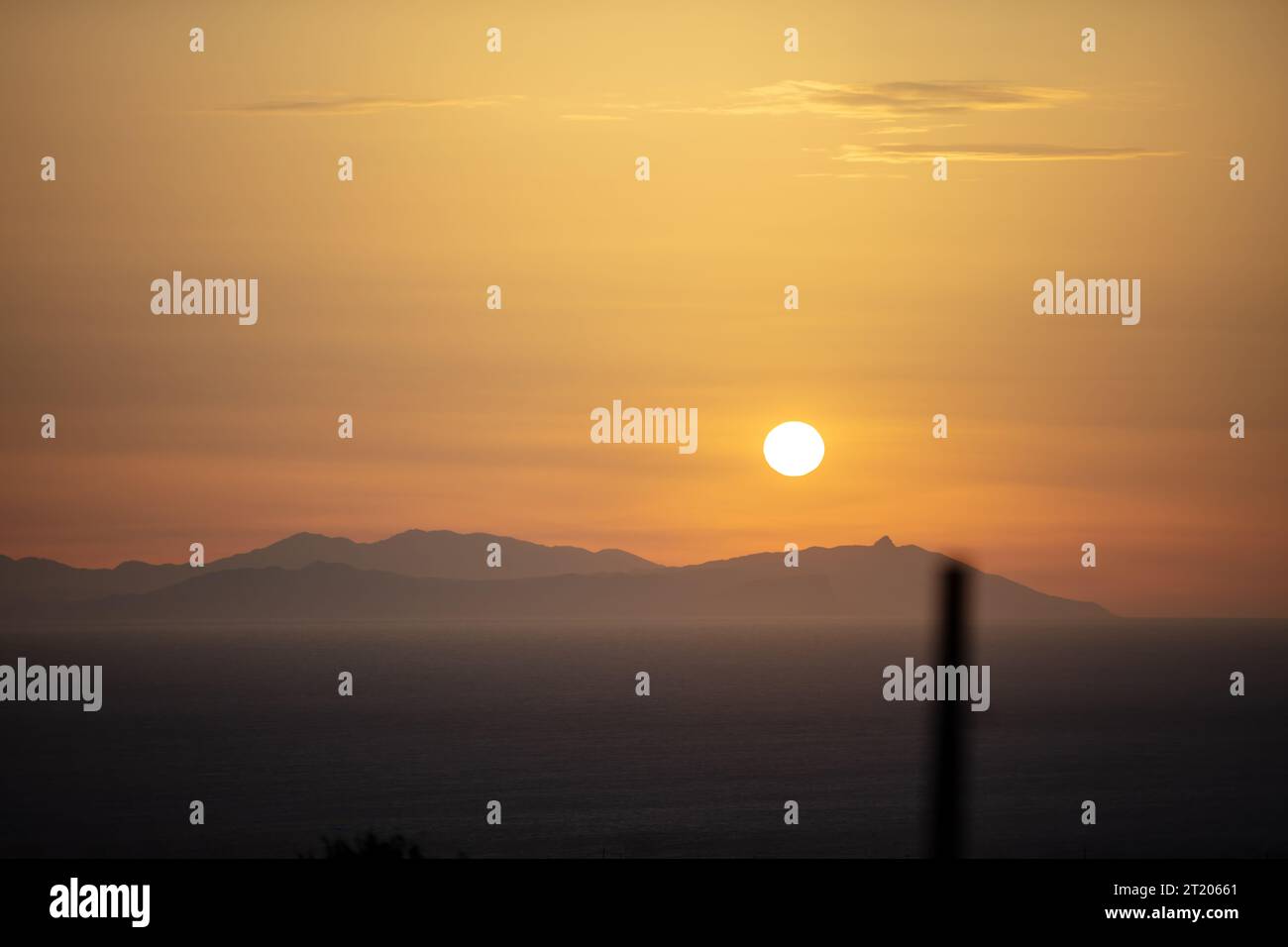 Sunset behind mountain silhouette over the sea on colorful sky ...