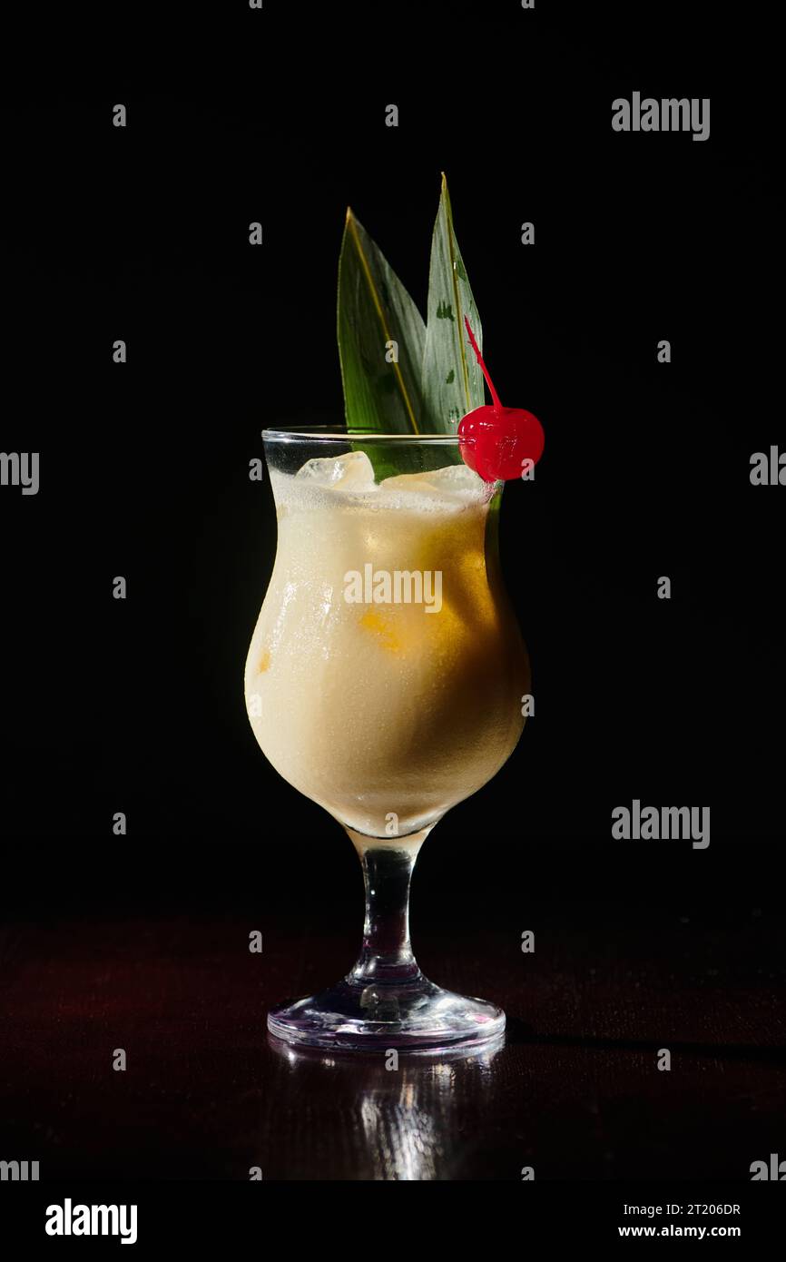 elegant pina colada with cocktail cherry on black background, object ...